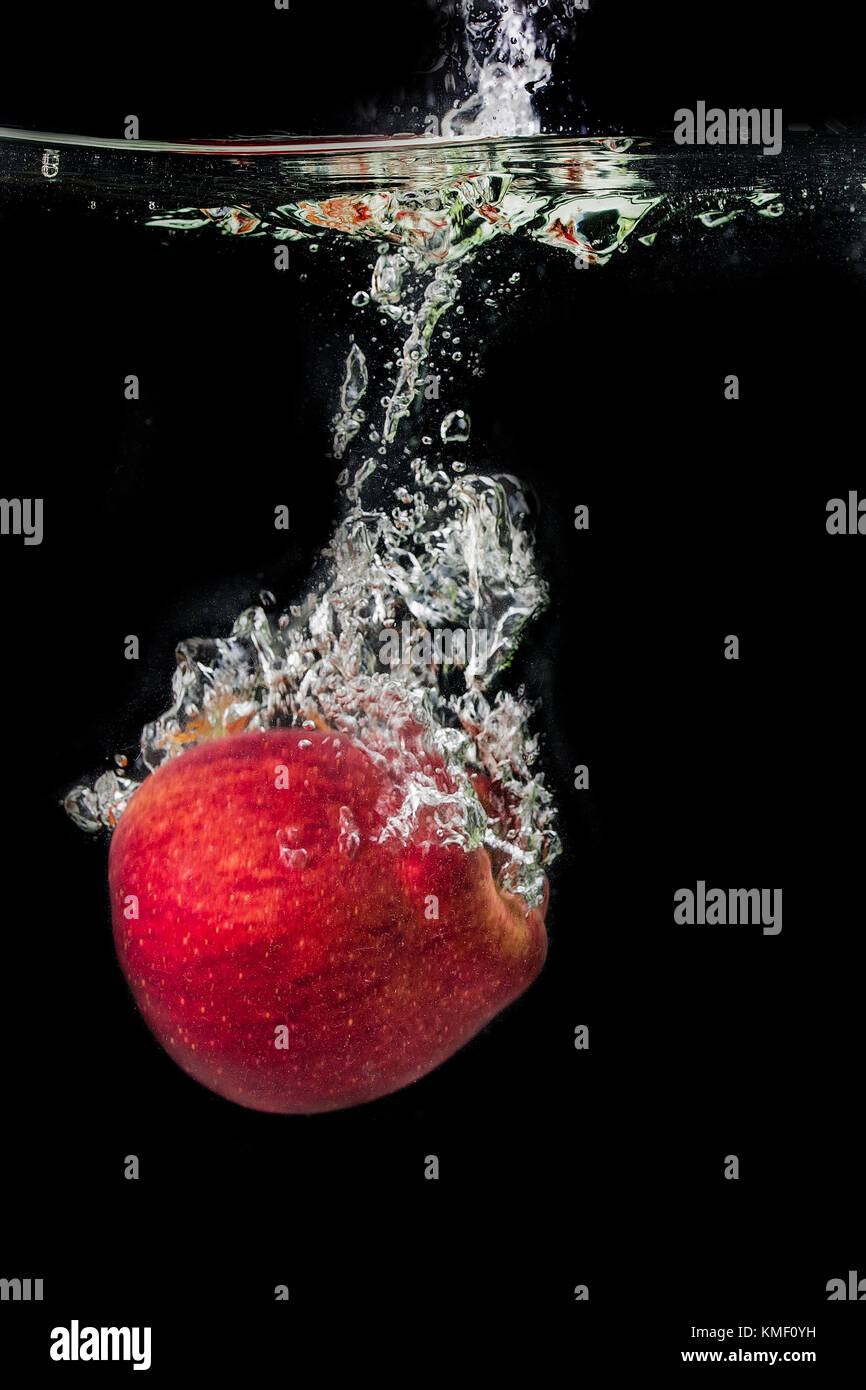 Apple falls into the water and makes a splash Stock Photo - Alamy