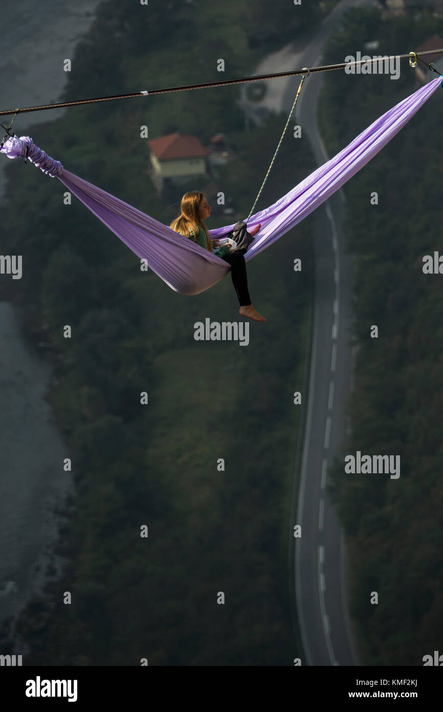Side view of woman sitting in hammock and hanging on high line,Tijesno ...