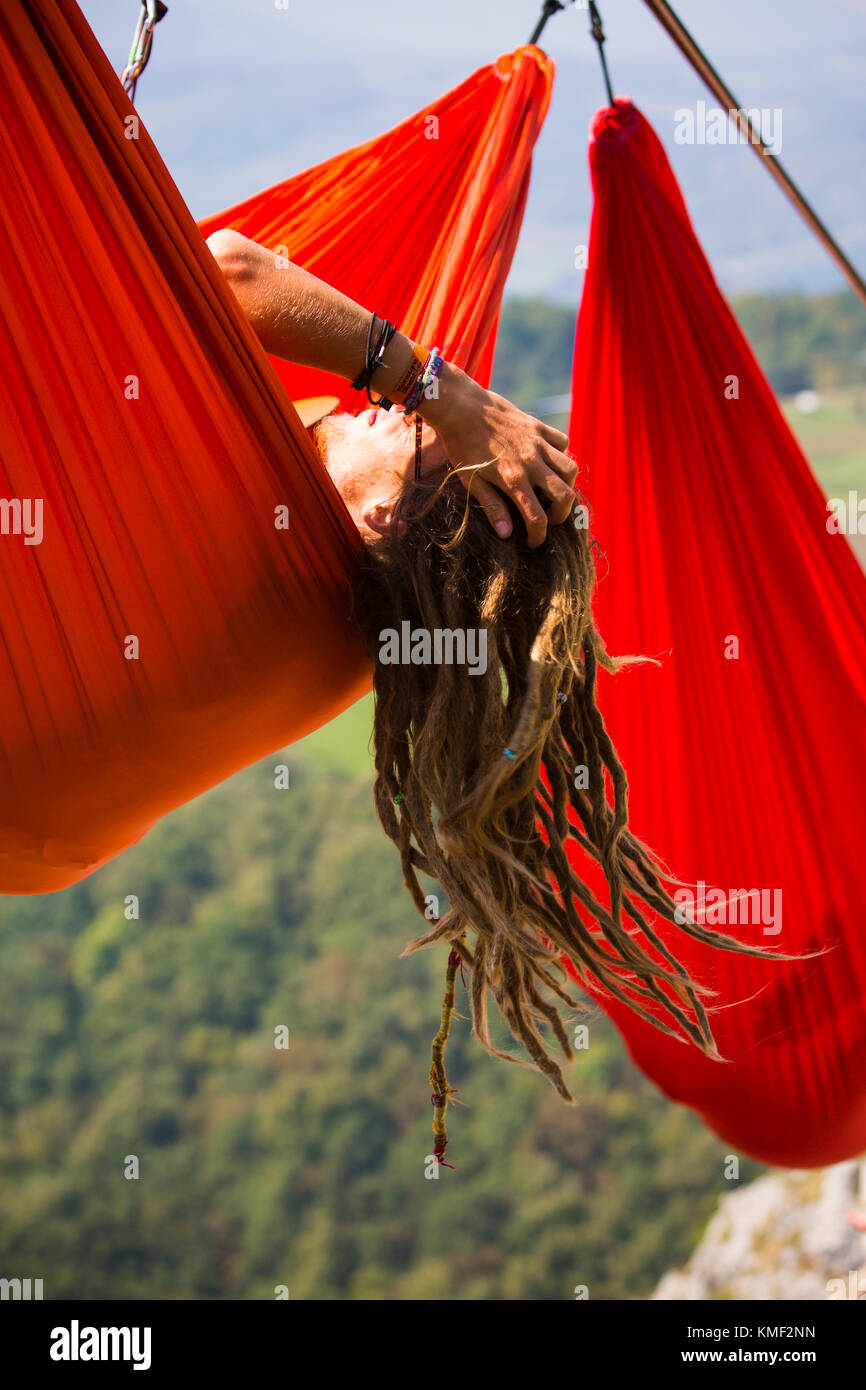 Side view of woman lying in red hammock above mountains,Tijesno Canyon ...
