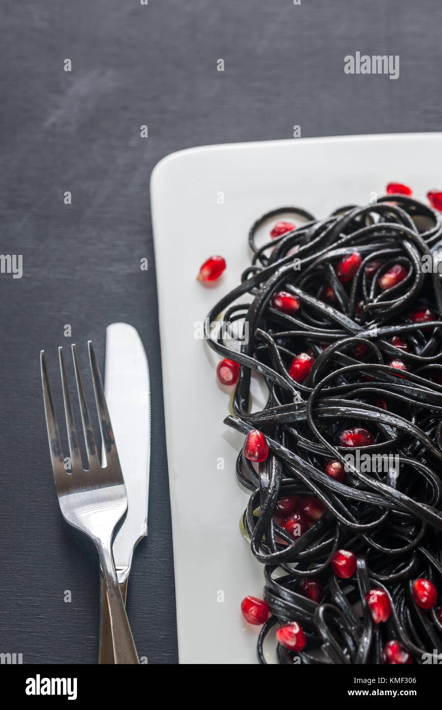 Black pasta with pomegranate seeds Stock Photo - Alamy
