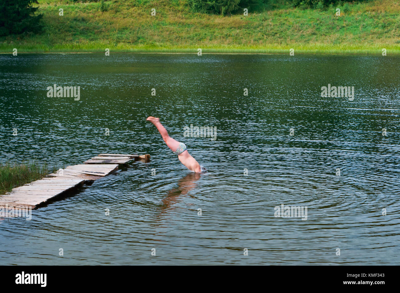 jump into the water, dive from the pier head down Stock Photo - Alamy