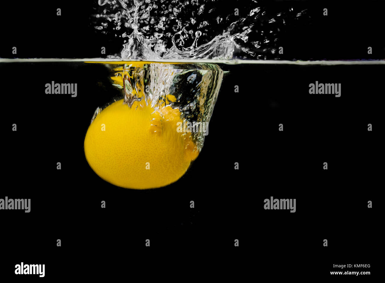 Lemon falls into the water and makes a splash Stock Photo - Alamy