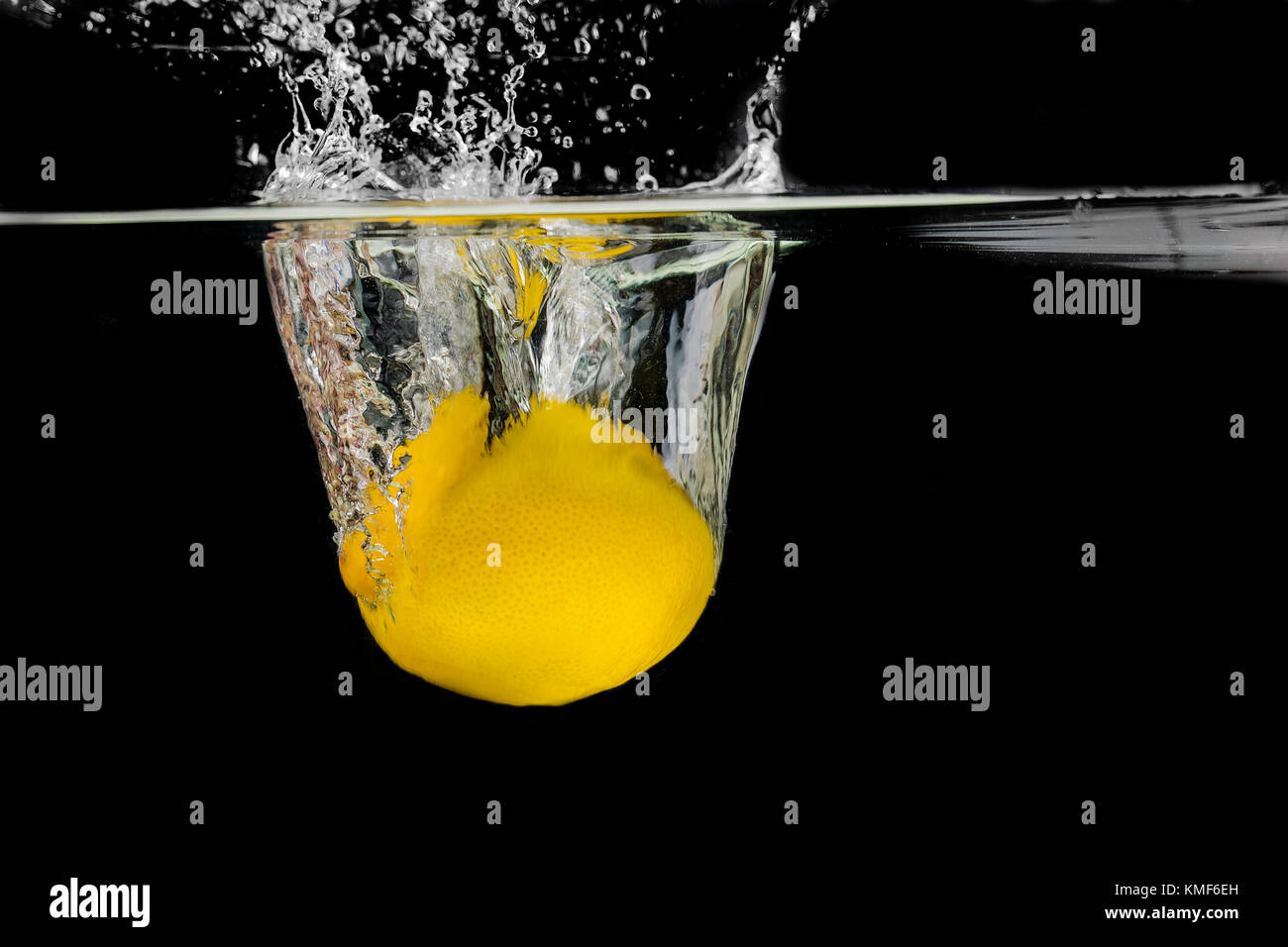 Lemon falls into the water and makes a splash Stock Photo - Alamy