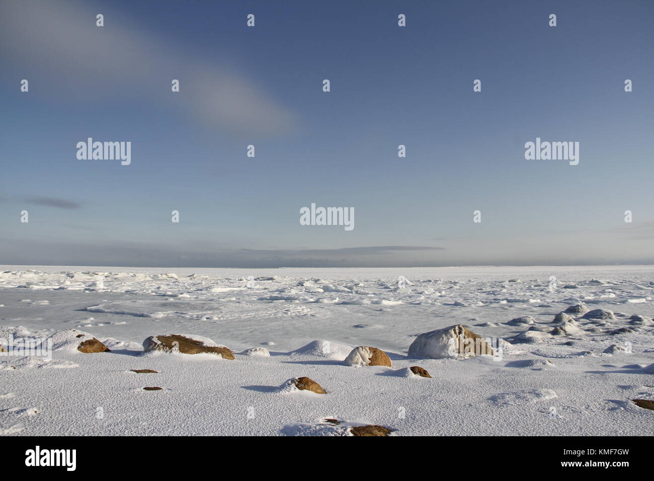 Rocks in the snow under a blue sky in the arctic, north of Arviat ...