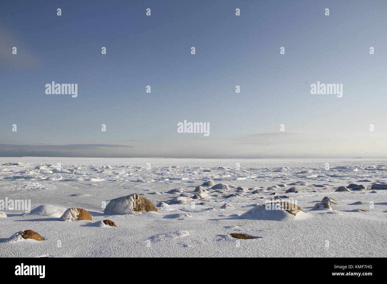 Rocks in the snow under a blue sky in the arctic, north of Arviat ...