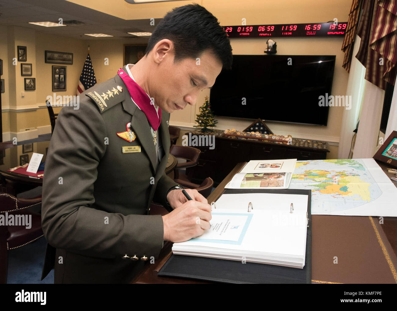 Singaporean chief of staff, Army Lt. Gen. Perry Lim Cheng Yeow, signs a ...