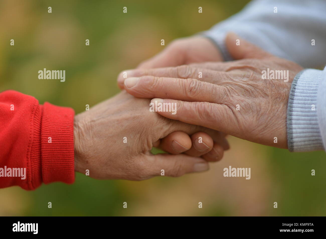 Elderly couple holding hands Stock Photo - Alamy
