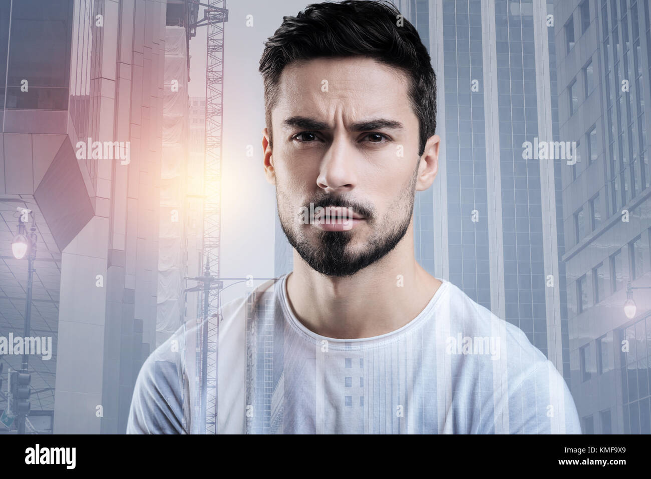 Bearded serious man frowning while watching the news Stock Photo - Alamy