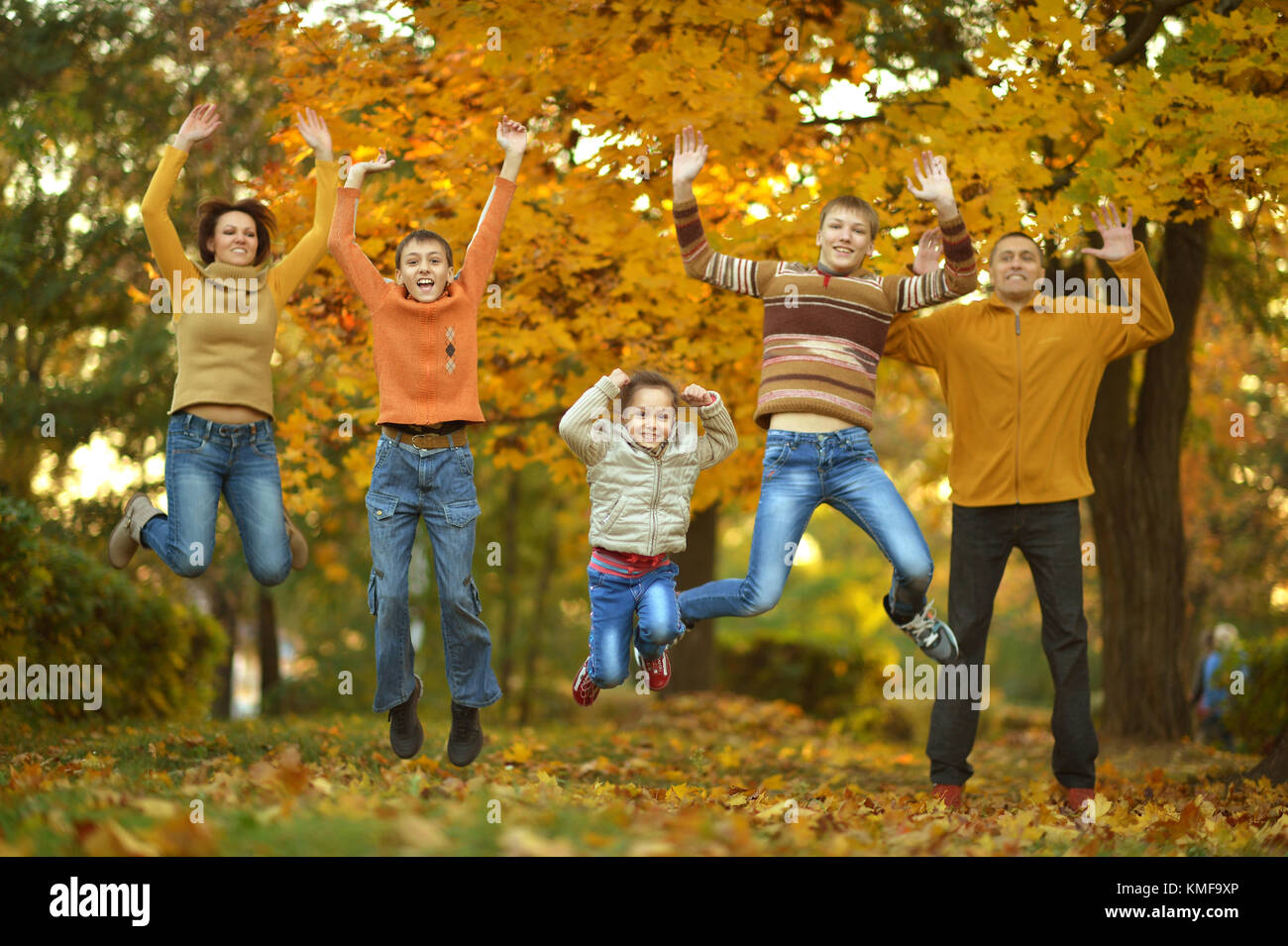 family jumping in autumn park Stock Photo - Alamy