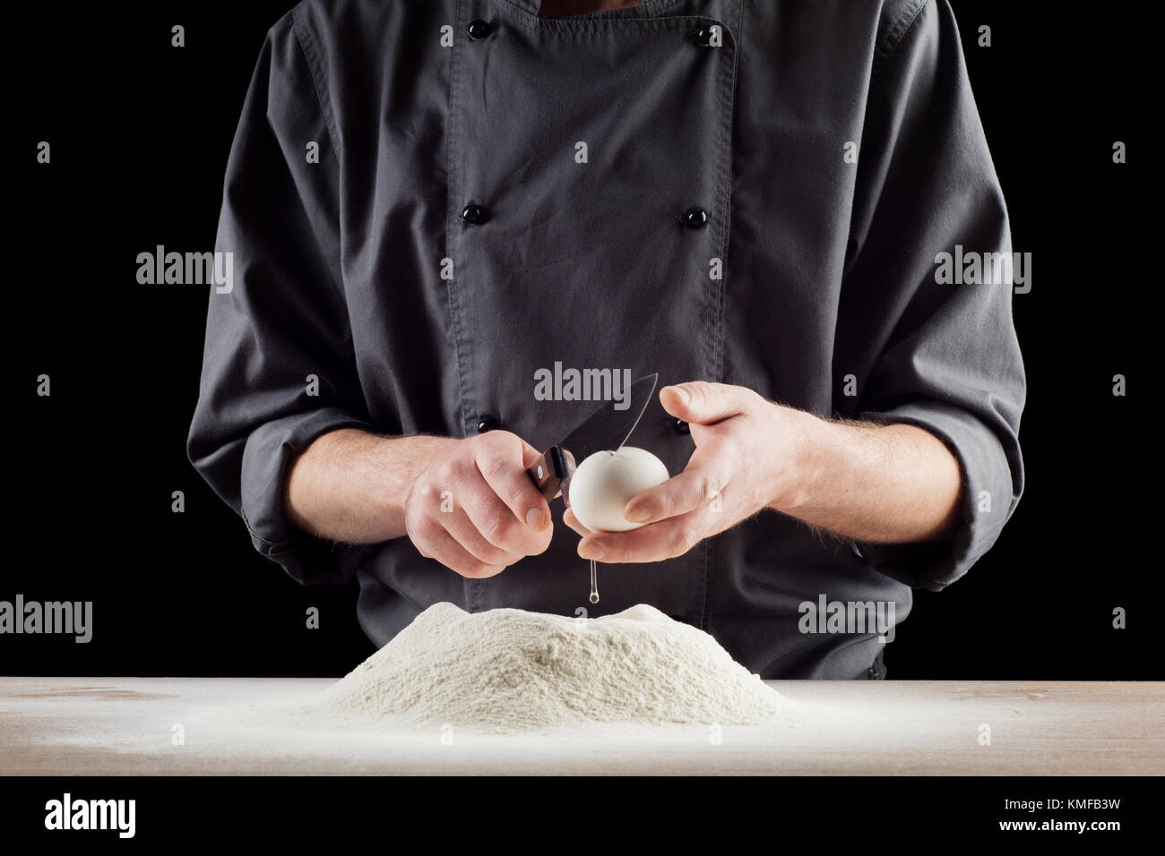 Closeup photo of baker cracking egg for dough Stock Photo - Alamy