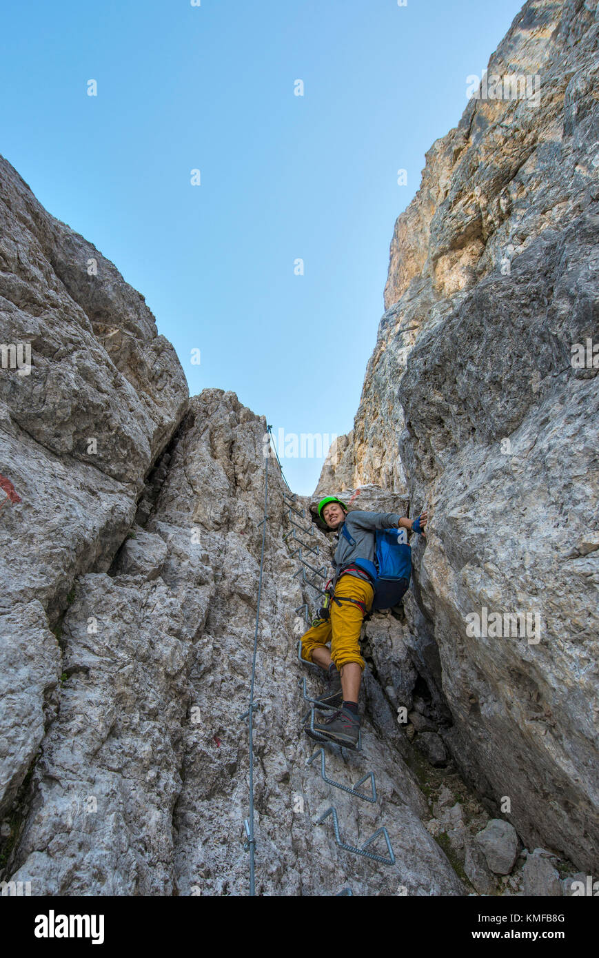 Hiker climbing in the Santner via ferrata, Rosengarten Group, Dolomites ...