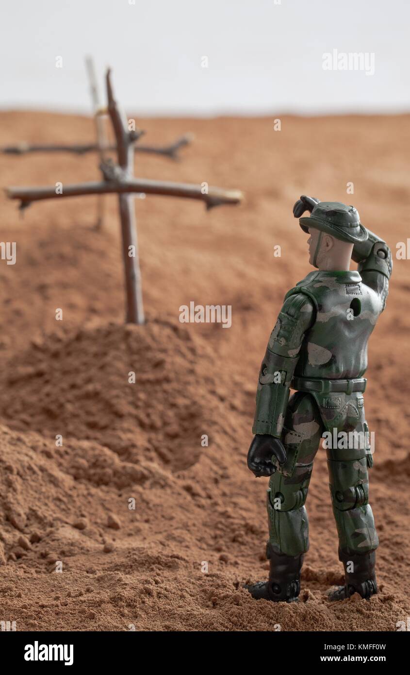 toy soldier giving a salute to his dead co soldier Stock Photo - Alamy