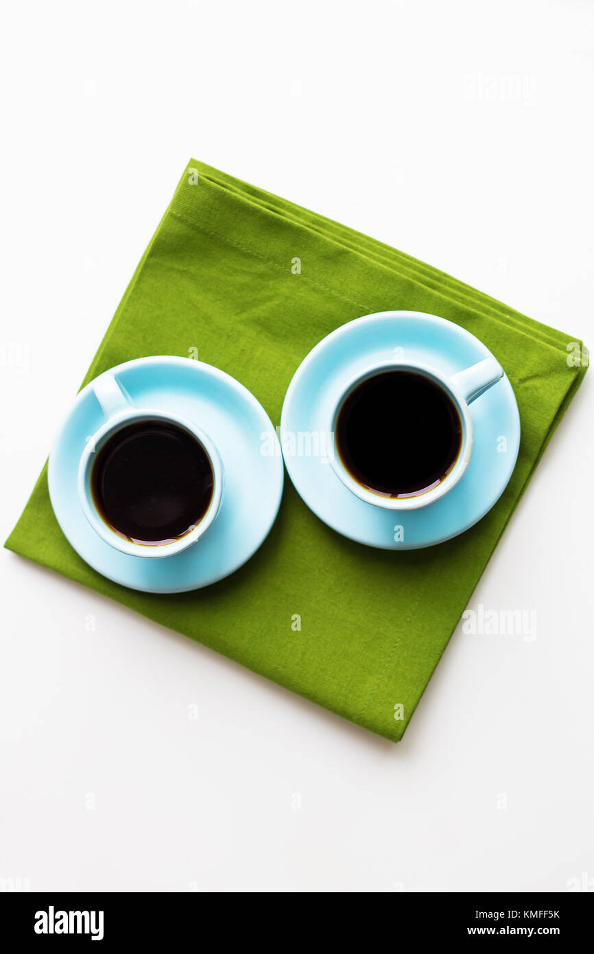 two blue cups of coffee on a table with green cloth Stock Photo - Alamy