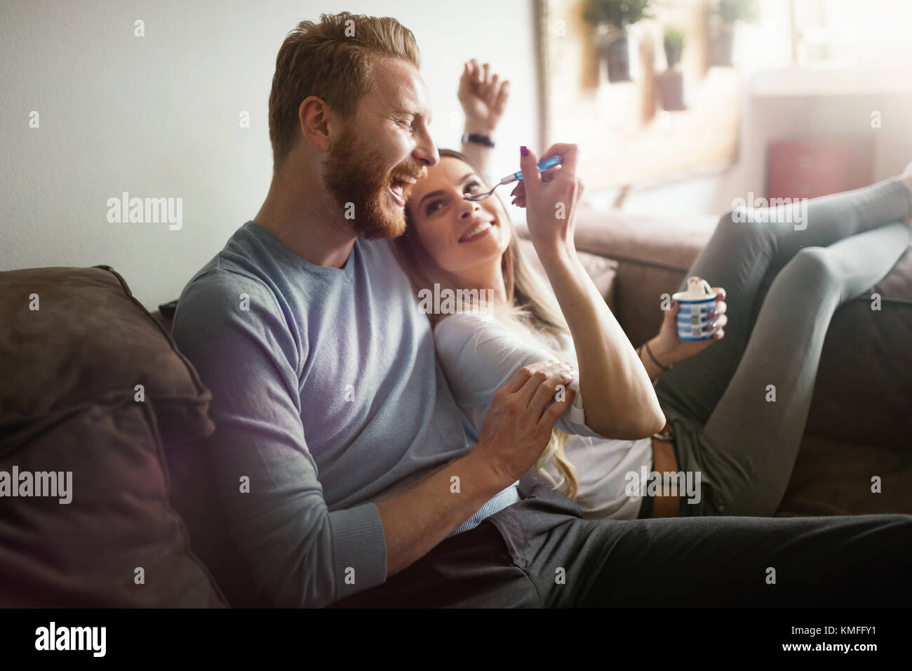 Romantic couple eating ice cream together and watching tv Stock Photo ...