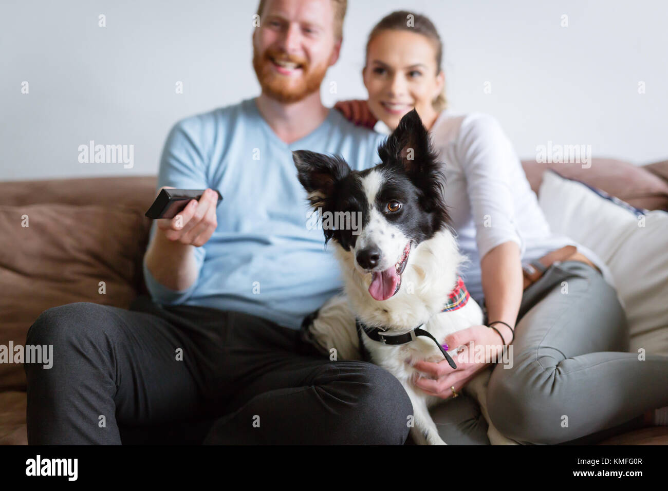Beautiful couple watching television at home with their dog Stock Photo ...