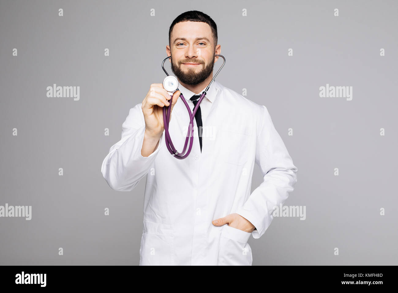 Friendly smiling medic or doctor holding stethoscope white background ...