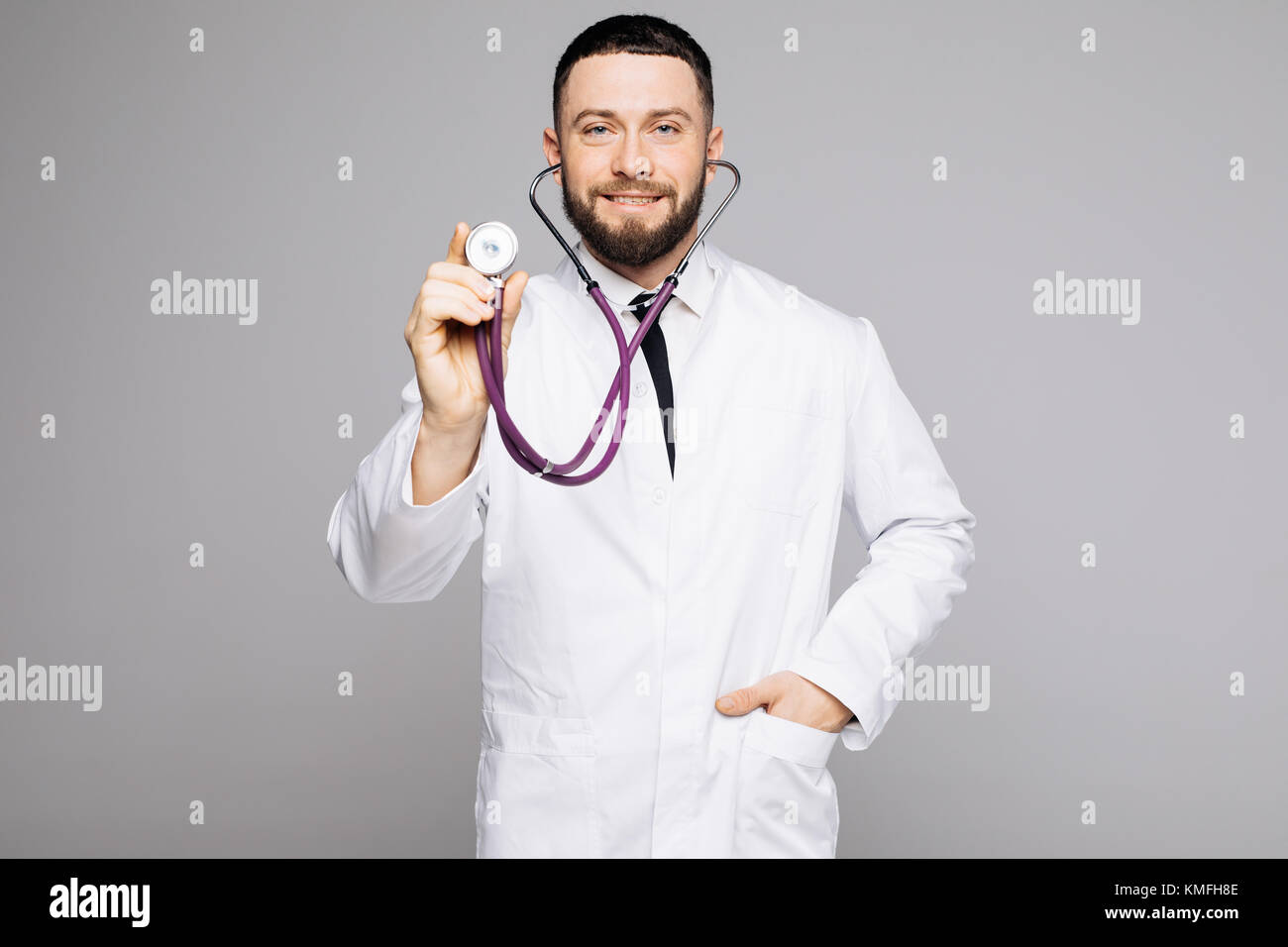 Friendly smiling medic or doctor holding stethoscope white background ...