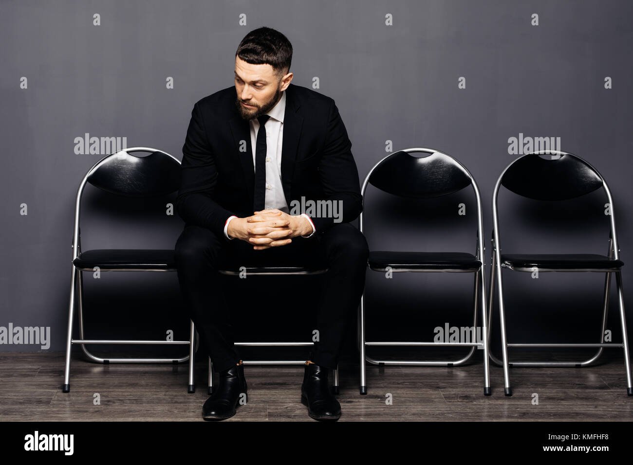 Young handsome man sitting on chair and waiting for his turn Stock ...
