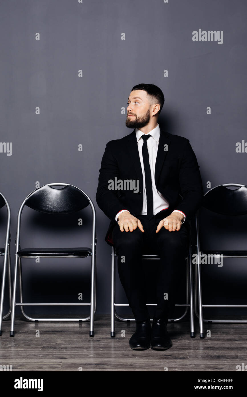 Young stylish man with beard is preparing for the interview. He is in a ...