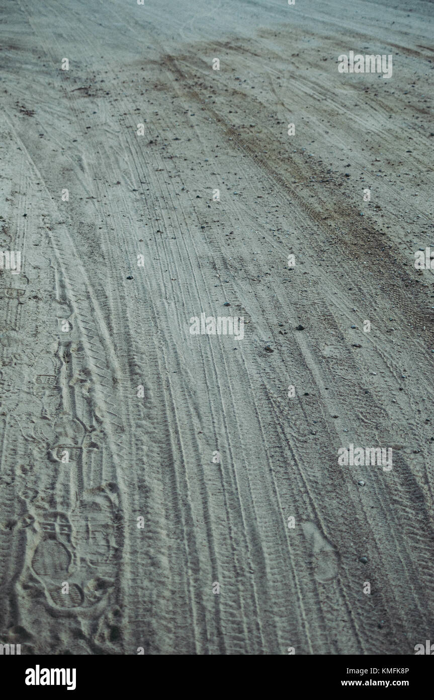 Tire marks and footprints in the sand Stock Photo - Alamy