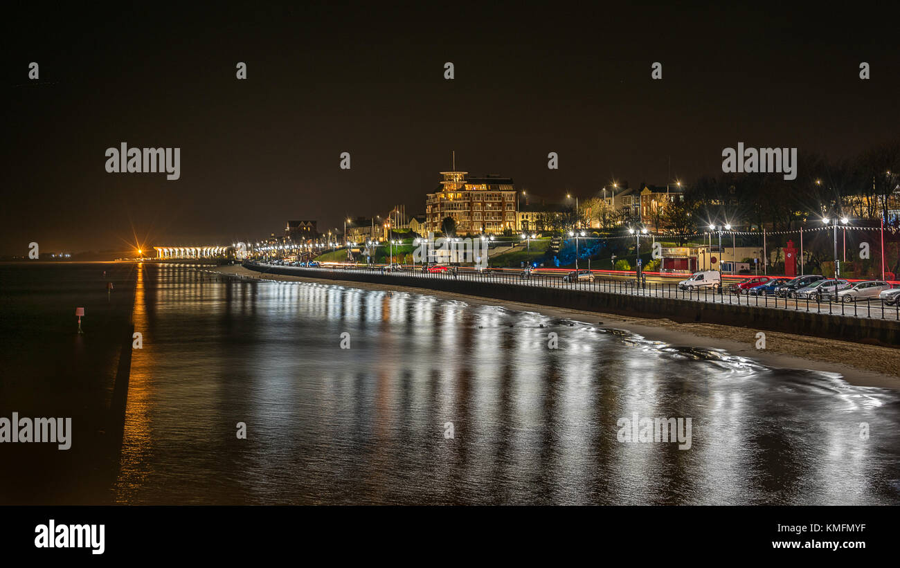 A night view of the promenade lit up and reflections in the sea of ...