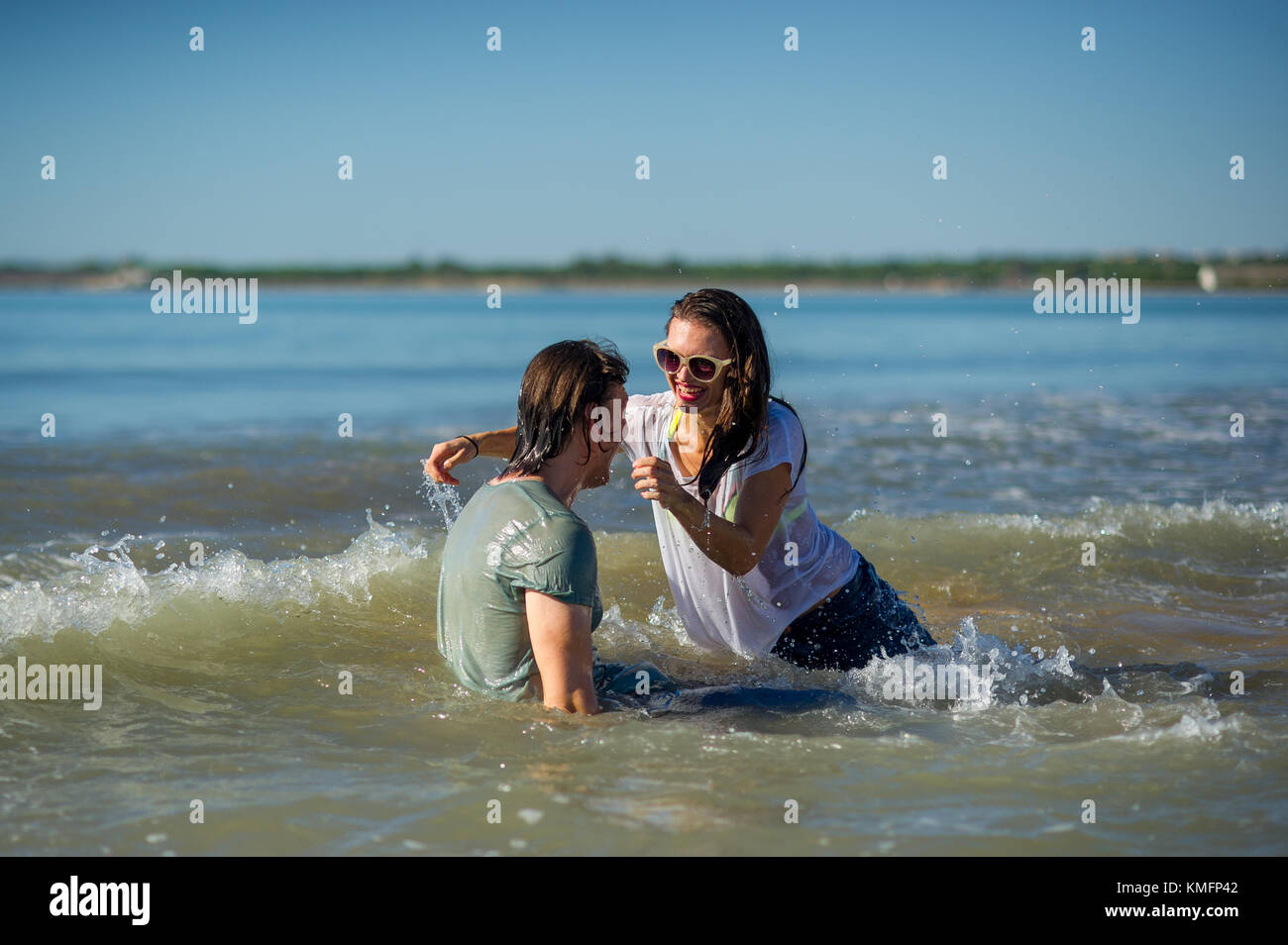 Young couple bathing in the sea. Guy and girl are merrily floundering ...