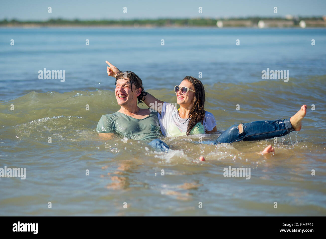 Young couple bathing in the sea. Guy and girl are merrily floundering ...