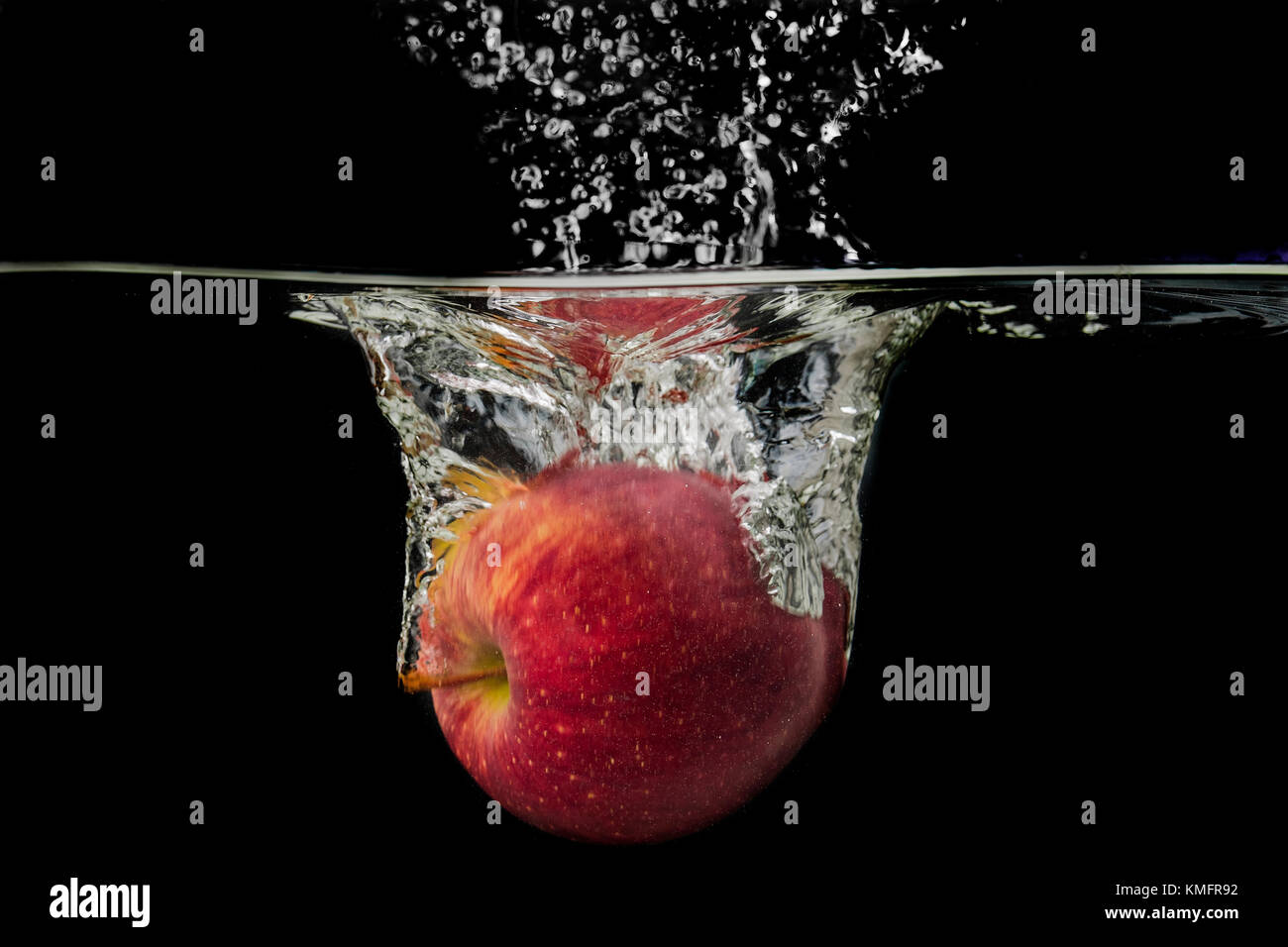 Apple falls into the water and makes a splash Stock Photo - Alamy