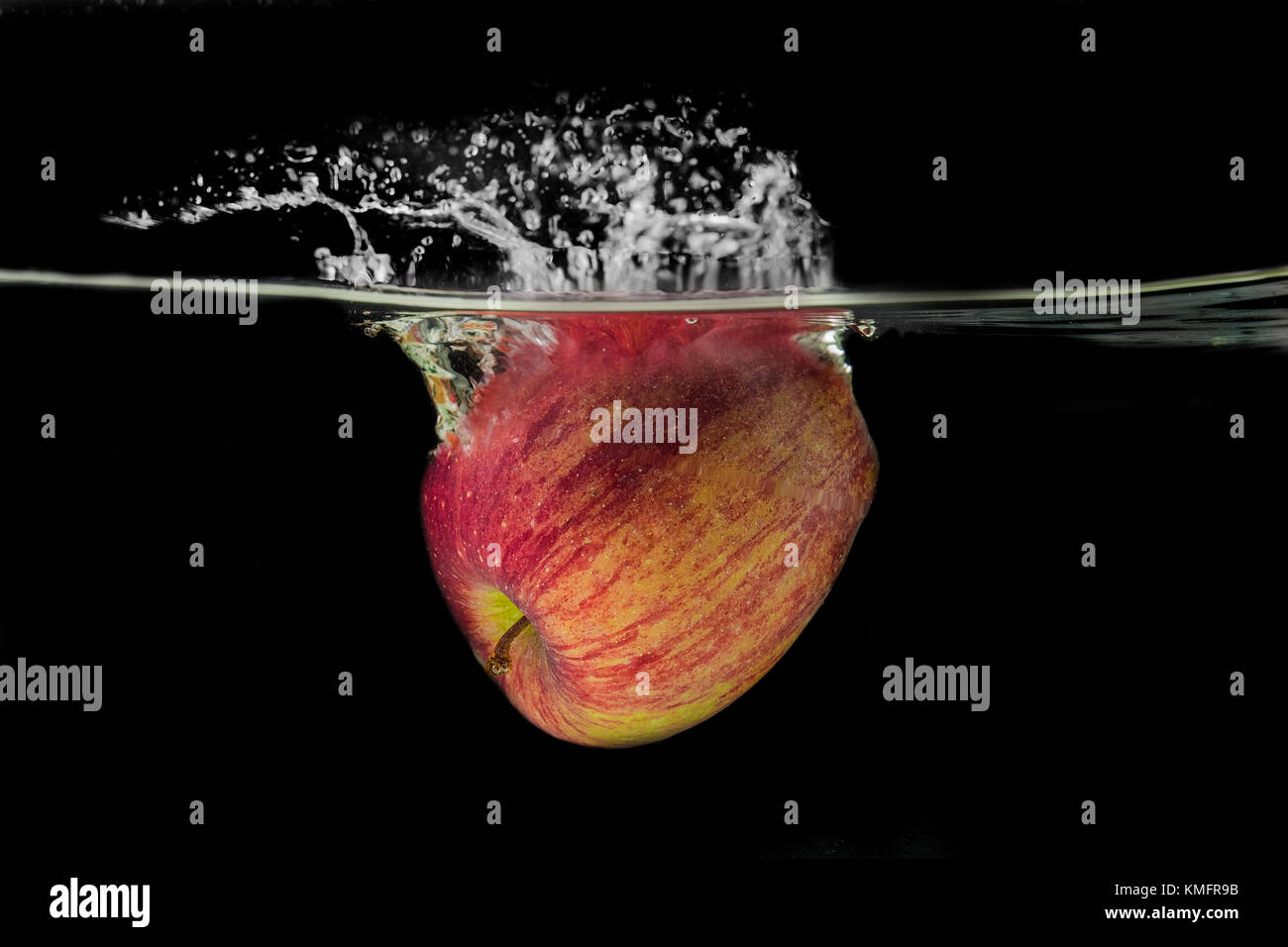 Apple falls into the water and makes a splash Stock Photo - Alamy