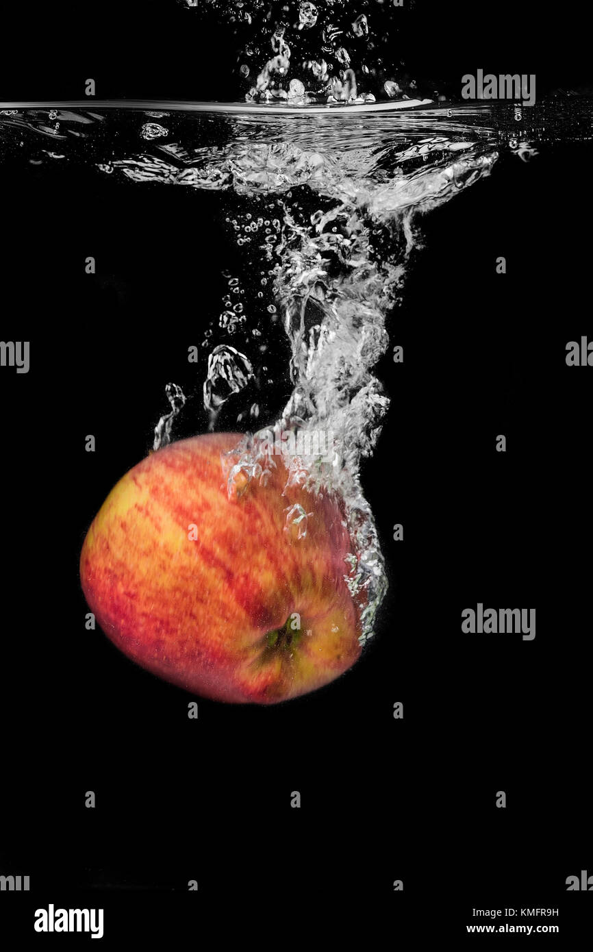 Apple falls into the water and makes a splash Stock Photo - Alamy