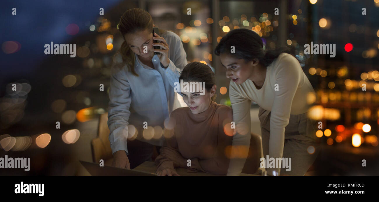 Businesswomen working late at laptop in office at night Stock Photo - Alamy