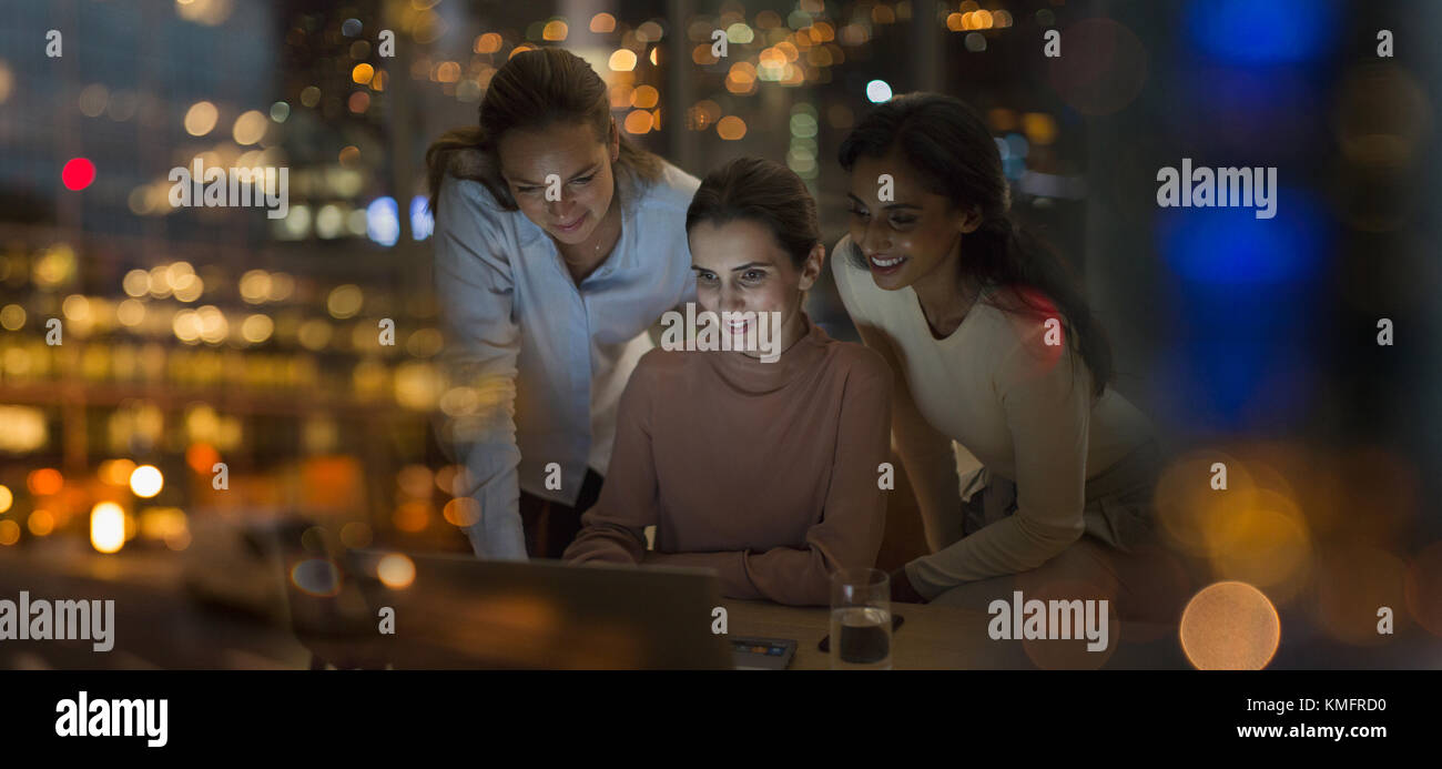 Businesswomen working late at laptop in office at night Stock Photo - Alamy