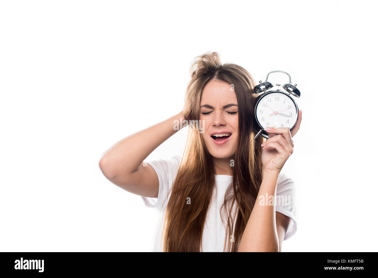 Sleepy girl holding alarm clock Stock Photo - Alamy
