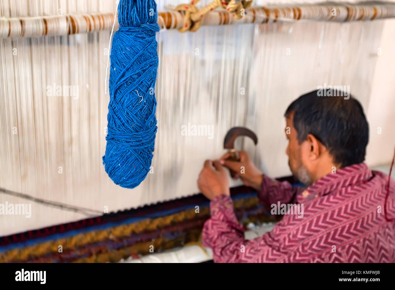 Back view man weaves carpet Stock Photo - Alamy
