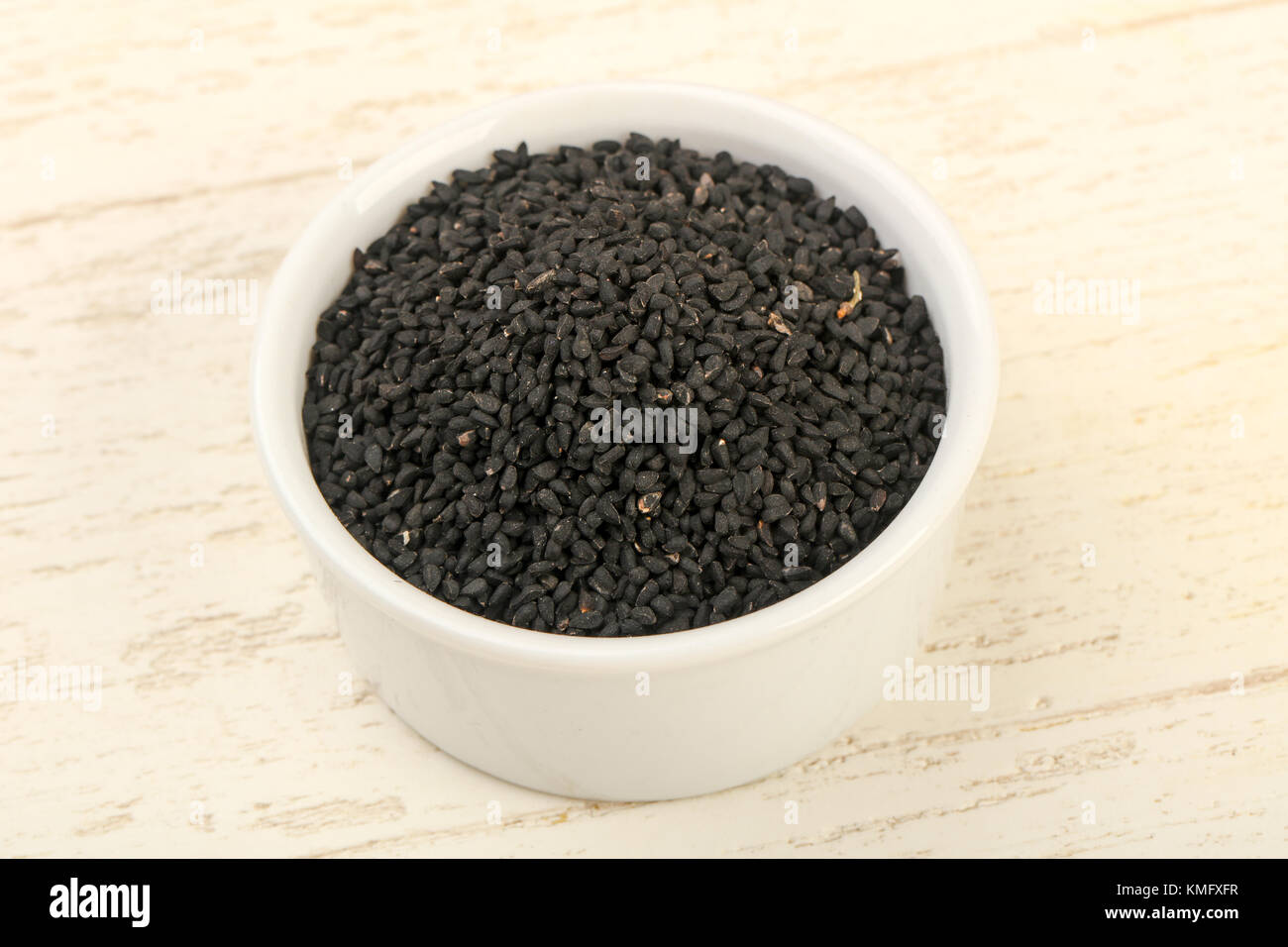 Black nigella seeds heap over wooden background Stock Photo - Alamy