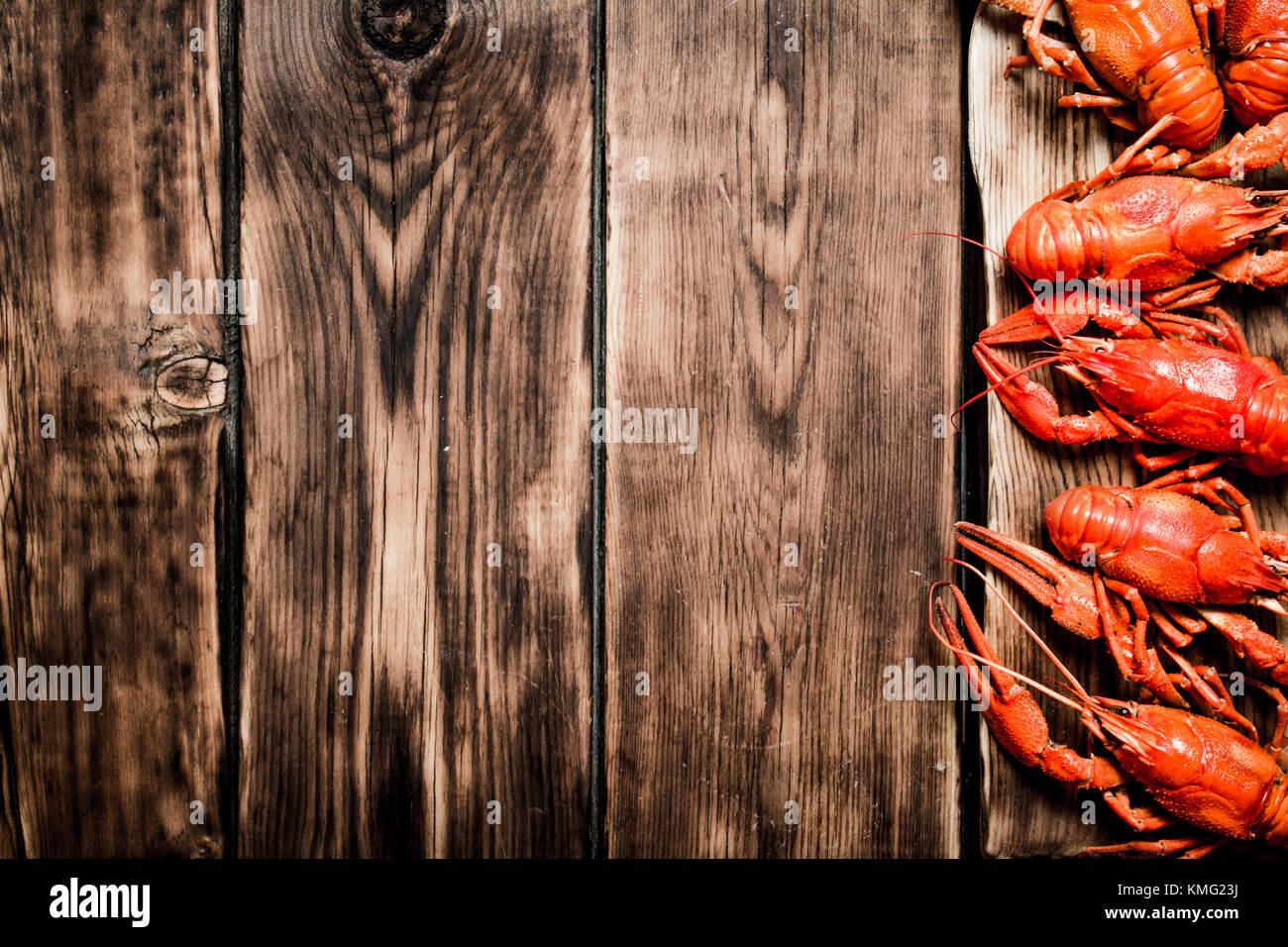 Fresh boiled crawfish on the old cutting Board. On Wooden background ...