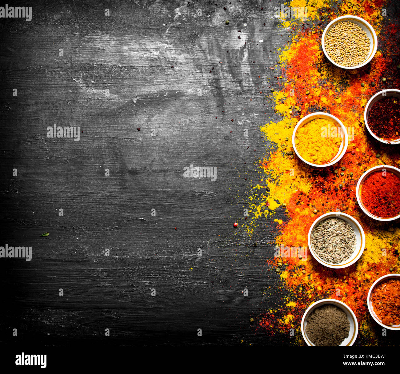 Big set of colored ground spices and herbs. On the black chalkboard ...