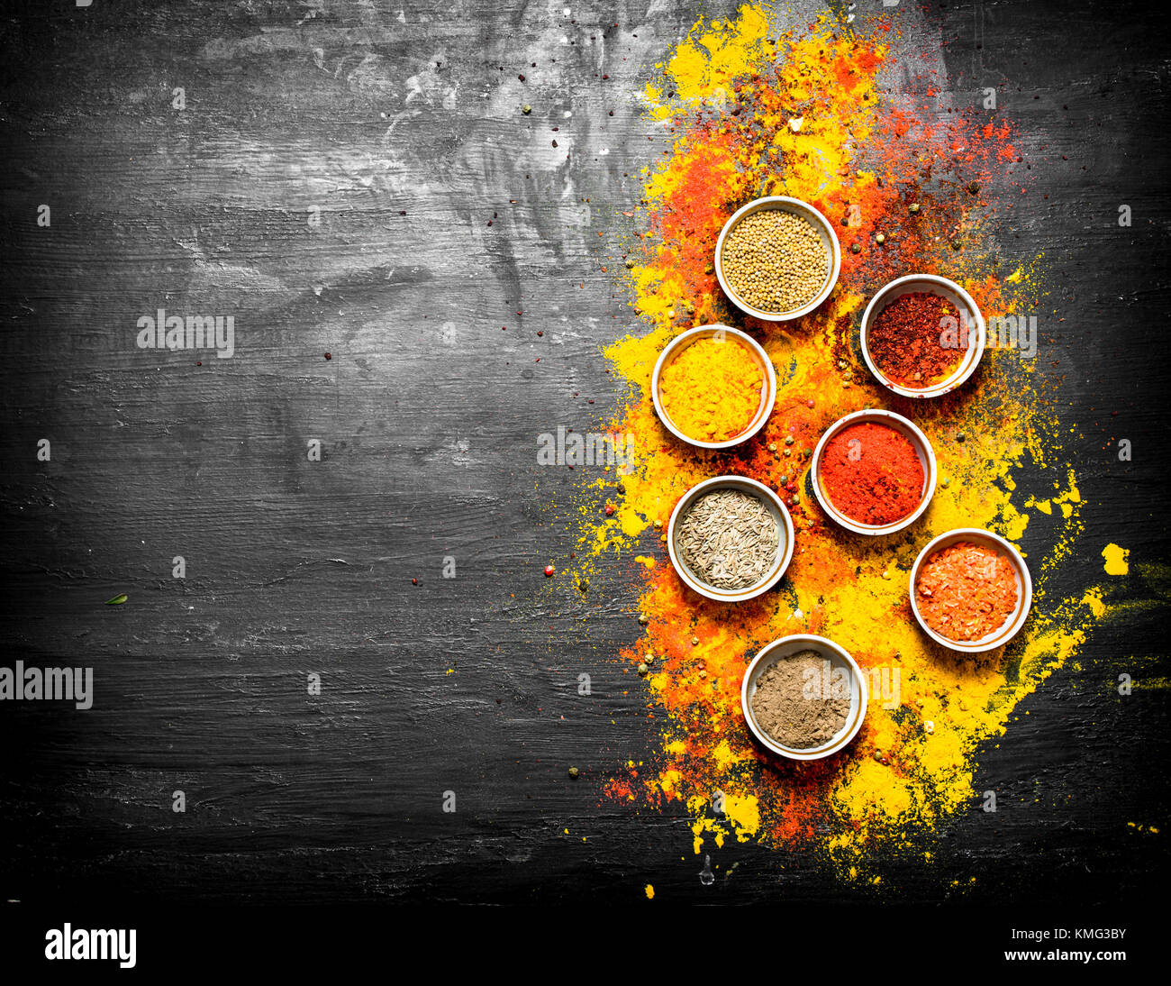 Big set of colored ground spices and herbs. On the black chalkboard ...