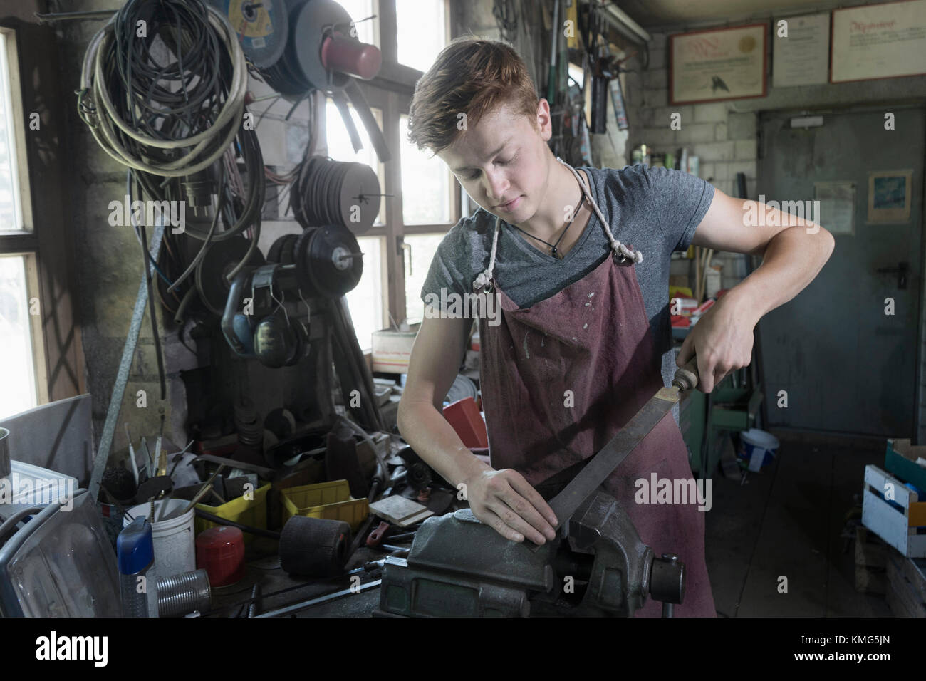 Blacksmith apprentice rasping iron fixed in plain vise Stock Photo - Alamy