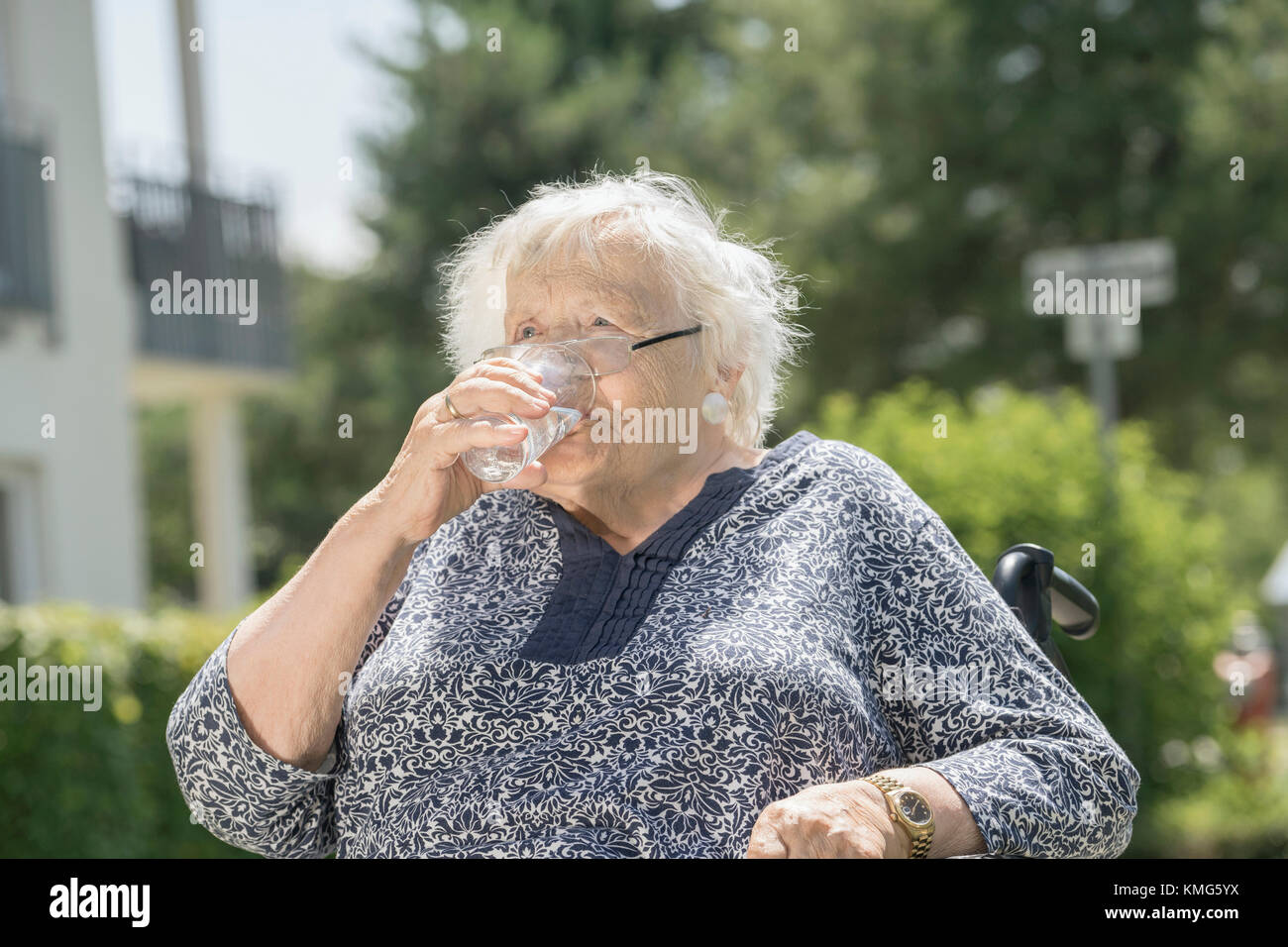Senior woman on wheelchair drinking a glass of water Stock Photo - Alamy