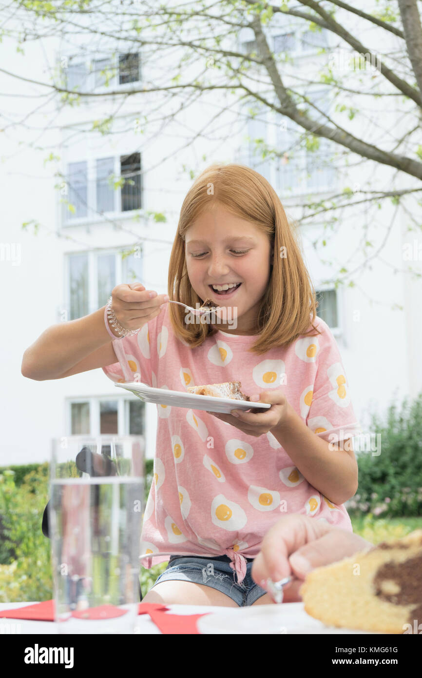 Young girl eating cake Stock Photo - Alamy