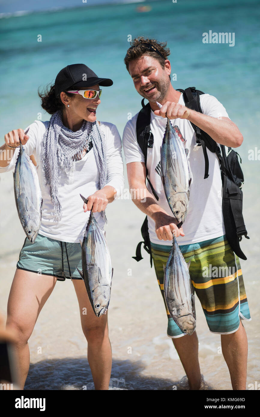 Man and woman with fresh fish at the beach Stock Photo - Alamy