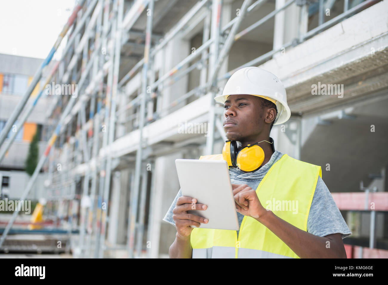 Construction worker holding digital tablet at building site Stock Photo ...