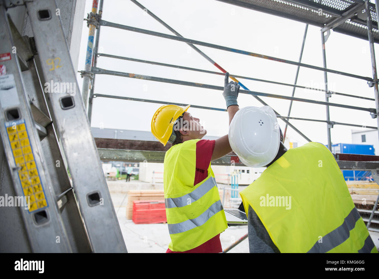Construction workers looking up at building site Stock Photo - Alamy