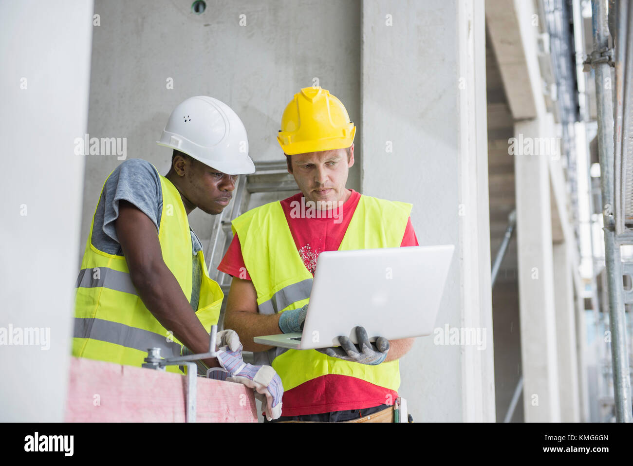Construction workers using laptop at site Stock Photo - Alamy