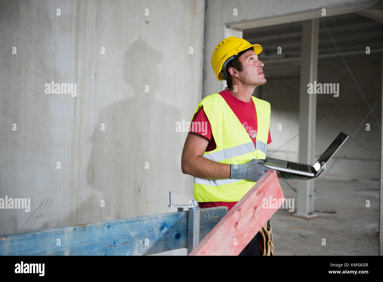 Construction worker with laptop at building site Stock Photo - Alamy