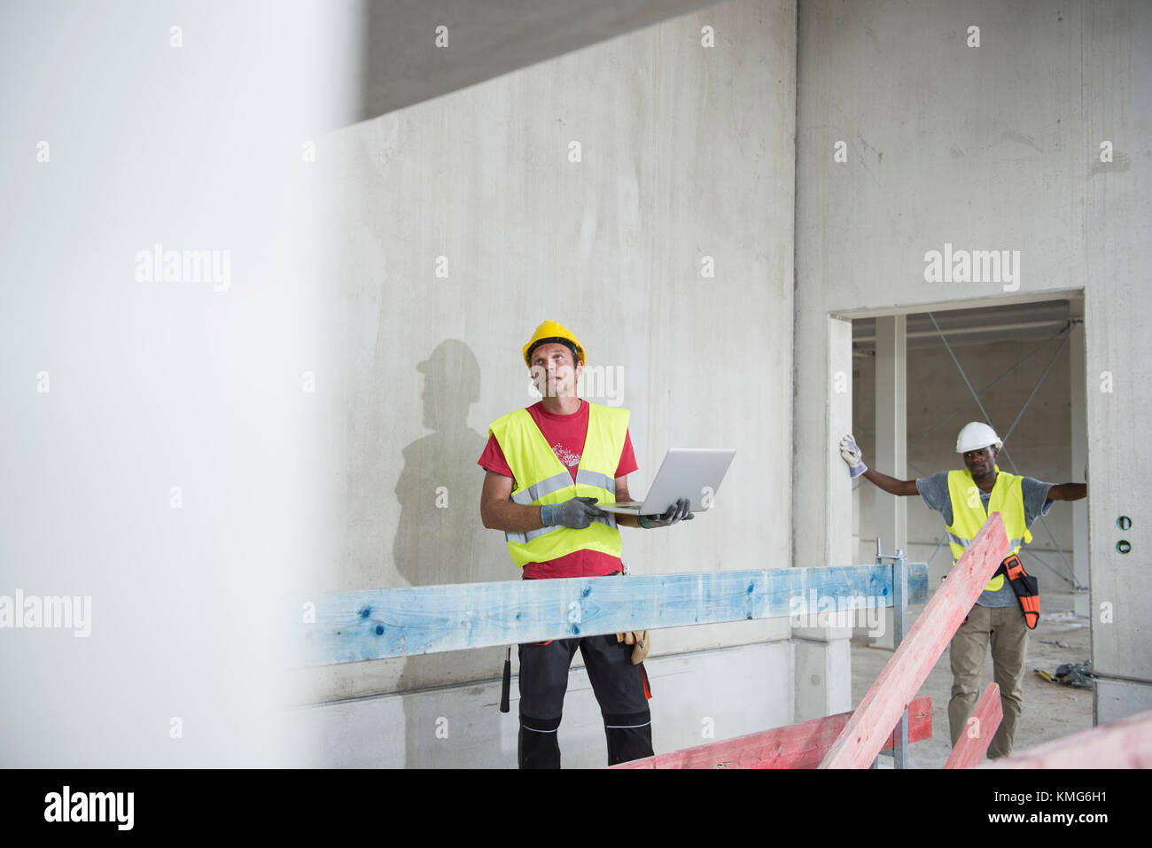 Construction workers with laptop at building site Stock Photo - Alamy