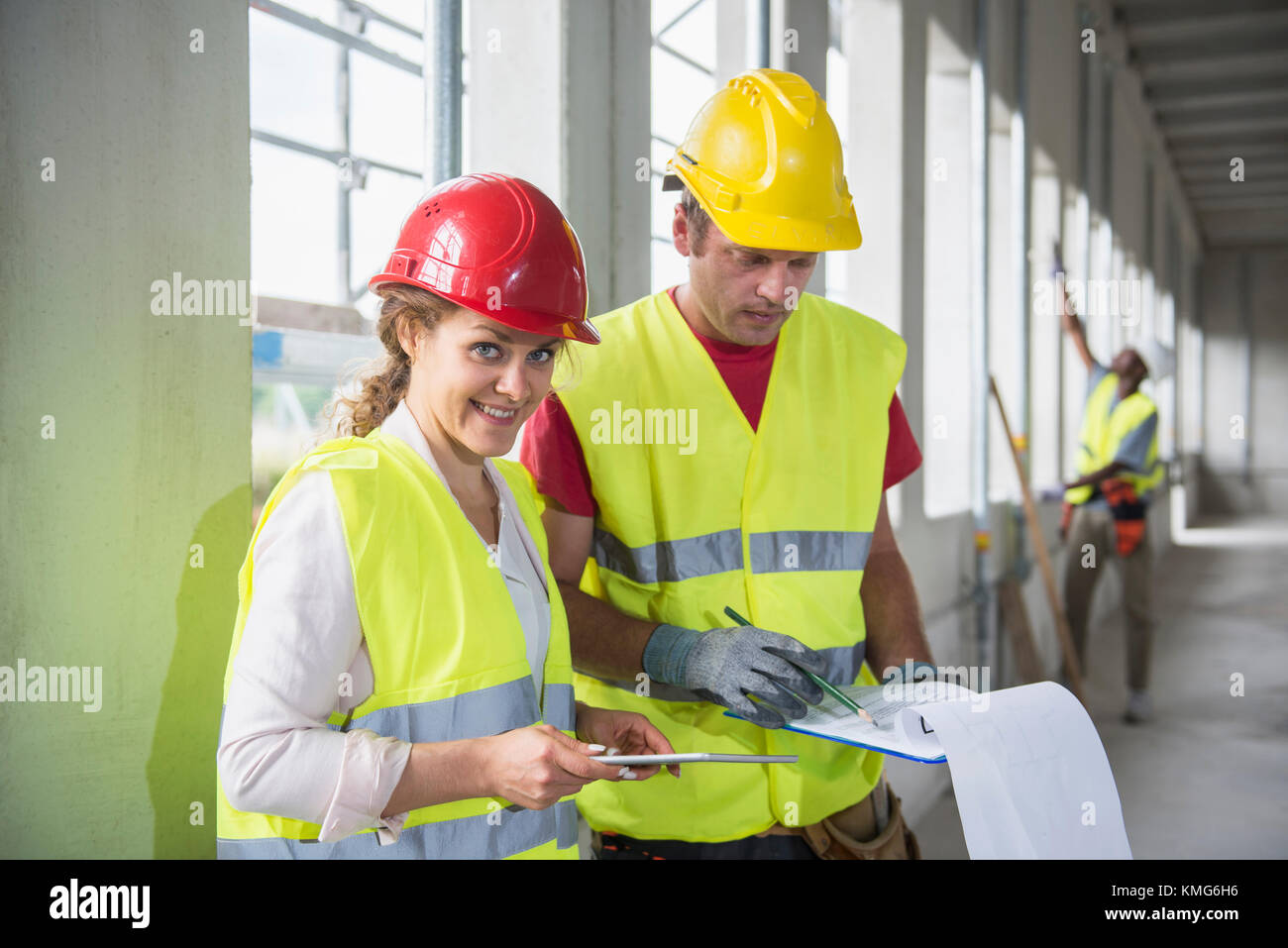 Construction workers with digital tablet and document at building site ...