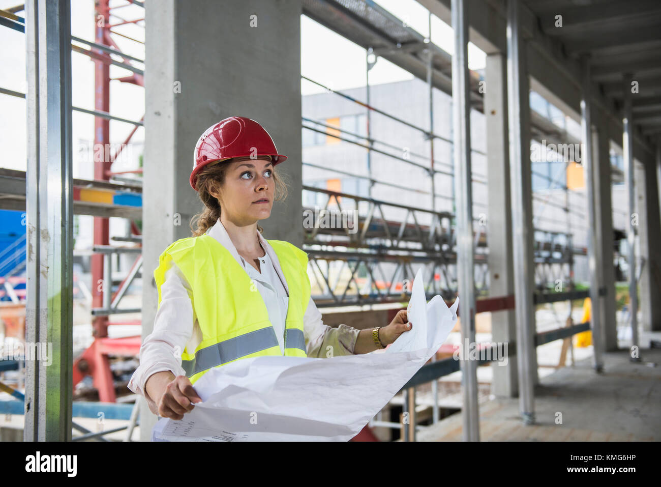 Female architect with blueprint at construction site Stock Photo - Alamy