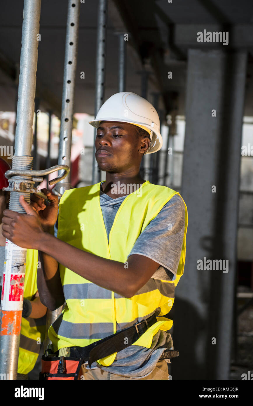 Construction worker fixing pillar in the basement of the building site ...